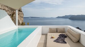 Varanda com piscina e área de estar com vista para o mar.