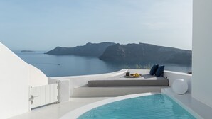 Uma piscina infinita moderna com vista para o mar e ilhas ao longe.