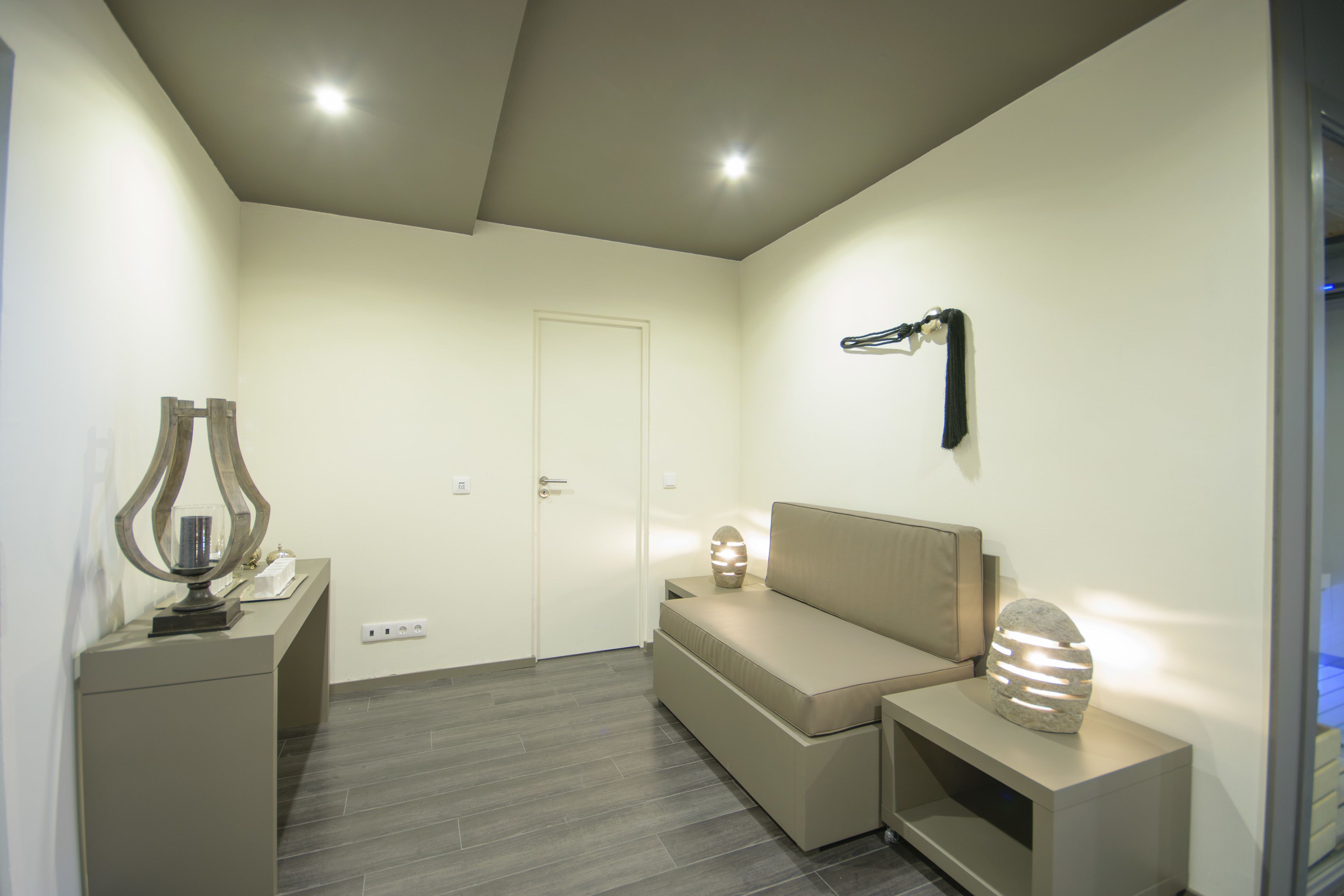 Quarto moderno com sofá-cama, mesas de cabeceira e abajur decorativo.