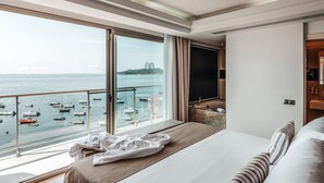 Quarto de hotel com uma grande janela com vista para uma marina e barcos.