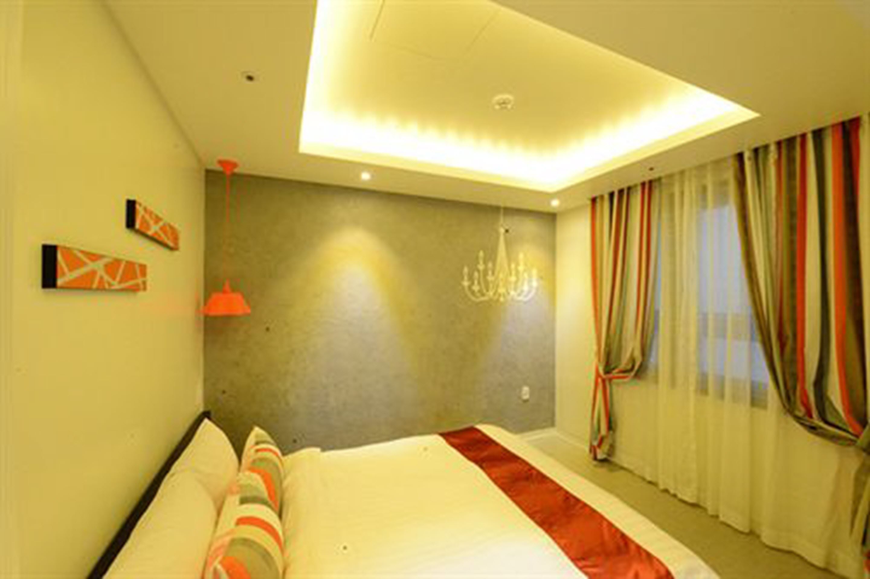 Um quarto com cama, um candelabro e cortinas.