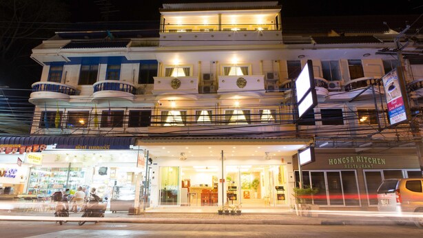 Um edifício de dois andares com um restaurante chamado "HONGSA KITCHEN" no andar térreo.