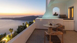 Uma varanda com mesa e cadeiras, oferecendo uma vista panorâmica do mar e das montanhas.