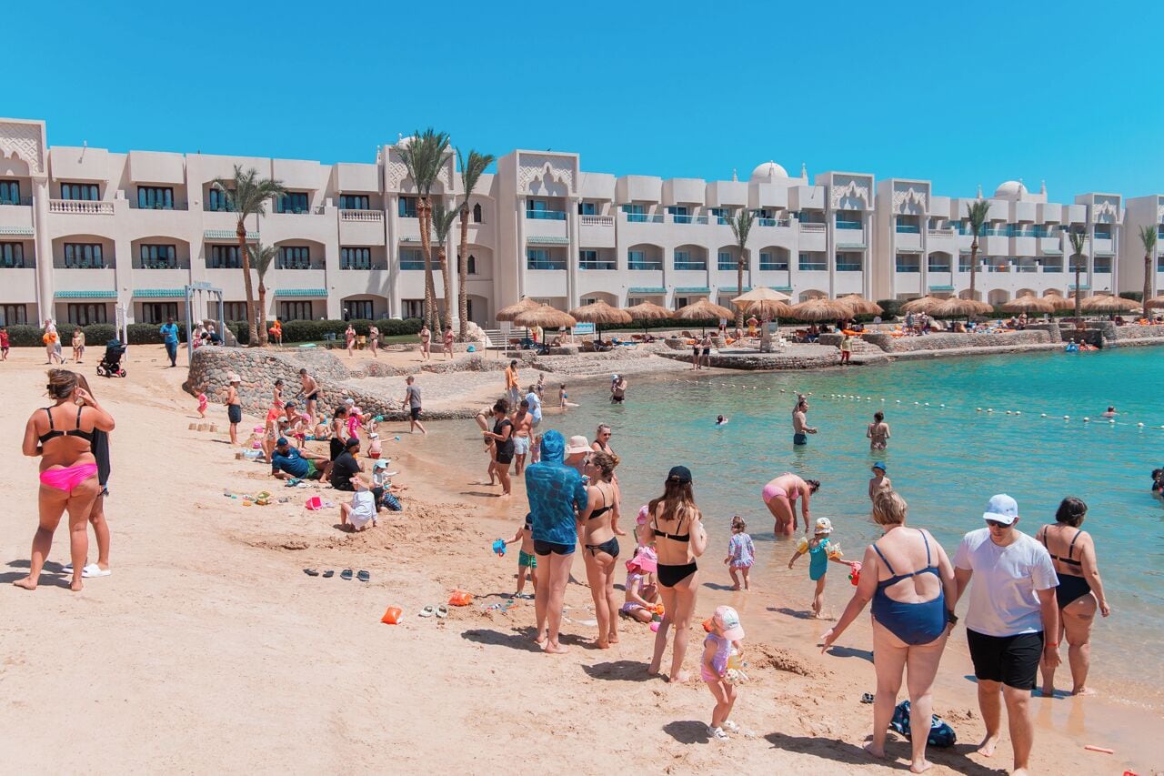 Um resort à beira-mar com vários edifícios de hotel, uma praia arenosa e área de piscina.