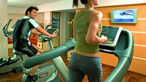 Uma academia com esteiras e aparelhos de ginástica.
