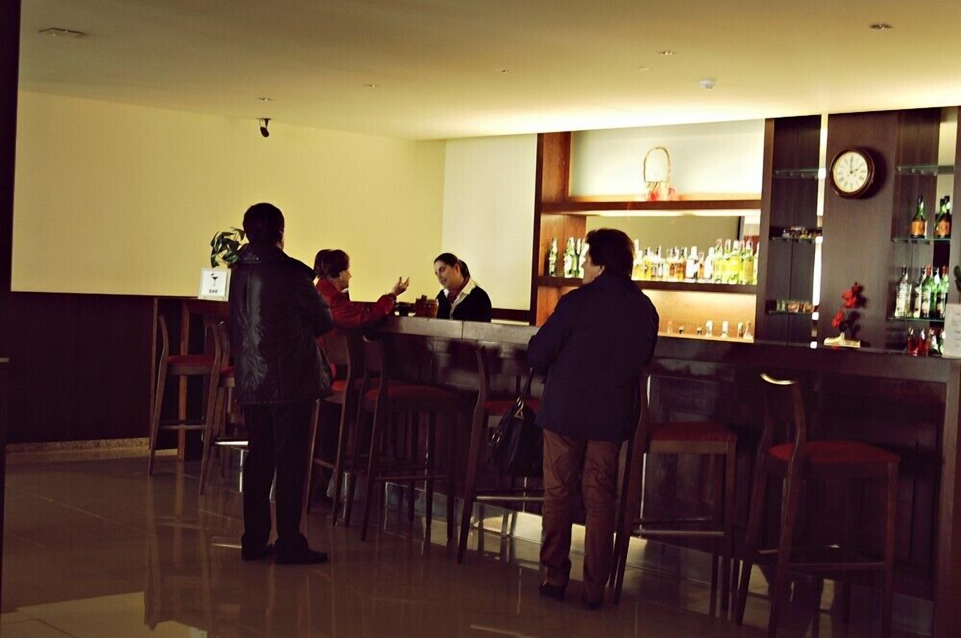 Uma área de bar com cadeiras de madeira e balcão.