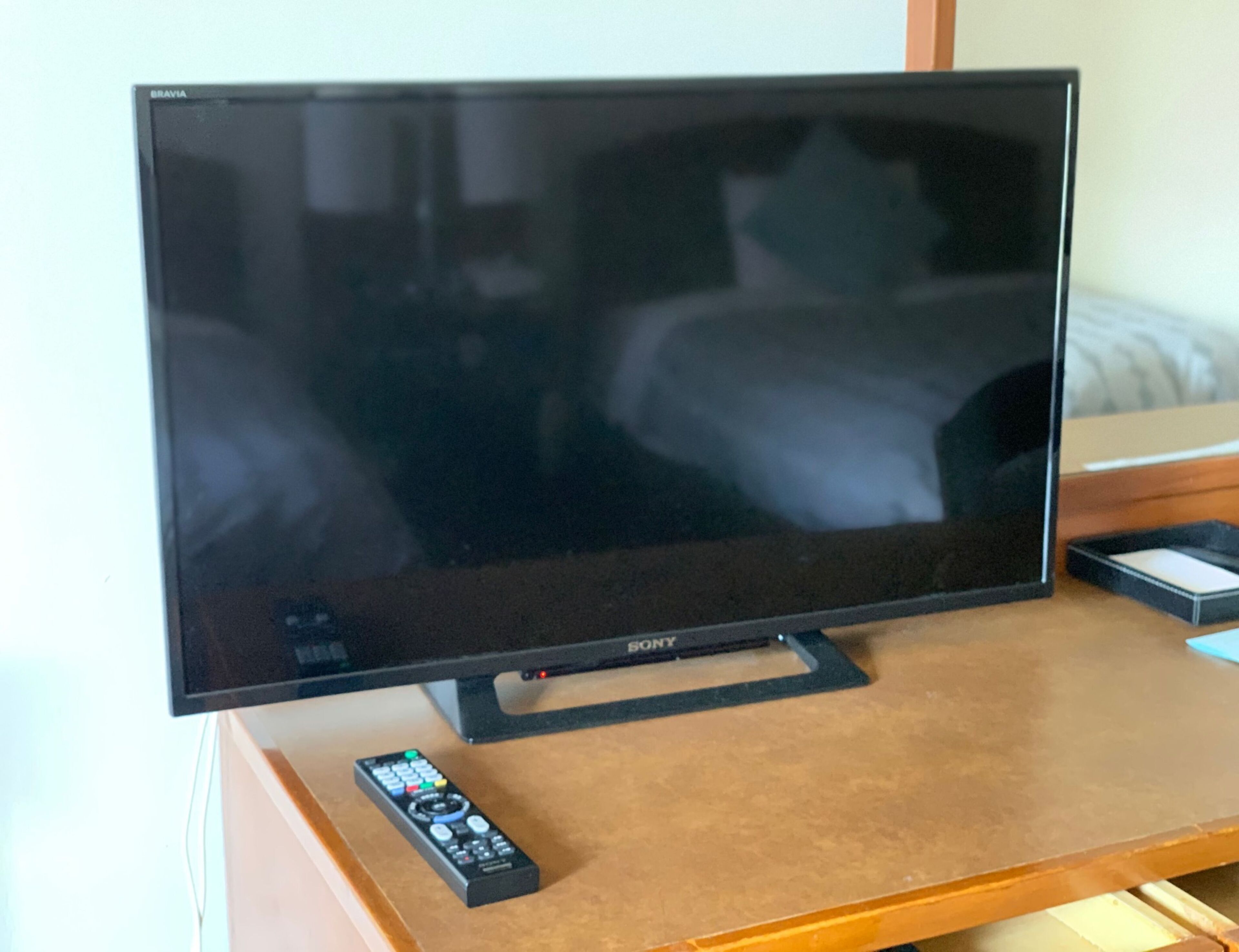 Televisão de tela plana em um suporte de madeira em um quarto.