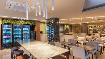 Um restaurante moderno com balcão de mármore, área de estar e exposição de vinhos.