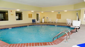 Piscina interior com placa de mergulho, regras da área da piscina e boias.
