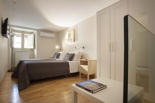 Quarto com cama, mesa de cabeceira e espelho.