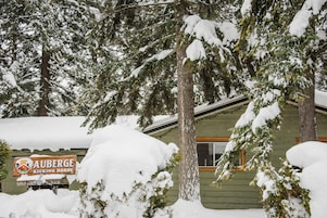 Um edifício coberto de neve com uma placa indicando 'Auberge Kicking Horse'.