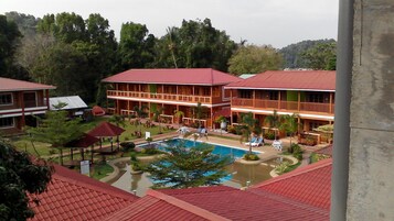 Um resort com piscina, edifícios de vários andares e um jardim ao redor.