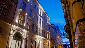 Um edifício histórico com arquitetura clássica, incluindo janelas em arco e detalhes ornamentados.