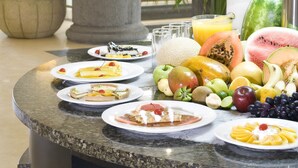 Buffet com diversas frutas, legumes e pratos prontos.
