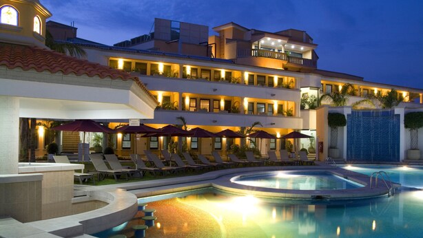 Um hotel com piscina, espreguiçadeiras e guarda-sóis.