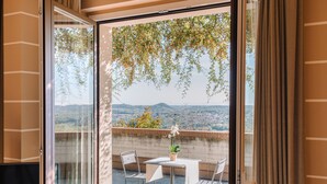 Quarto com uma grande porta de correr de vidro que dá para um terraço ao ar livre com mesa e cadeiras.