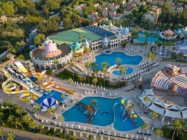 Resort com várias piscinas, toboáguas e um edifício central amplo com cúpulas.