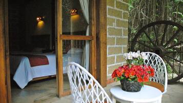 Um espaço ao ar livre com cama, mesa e um arranjo de flores, além de uma grande estrutura circular.
