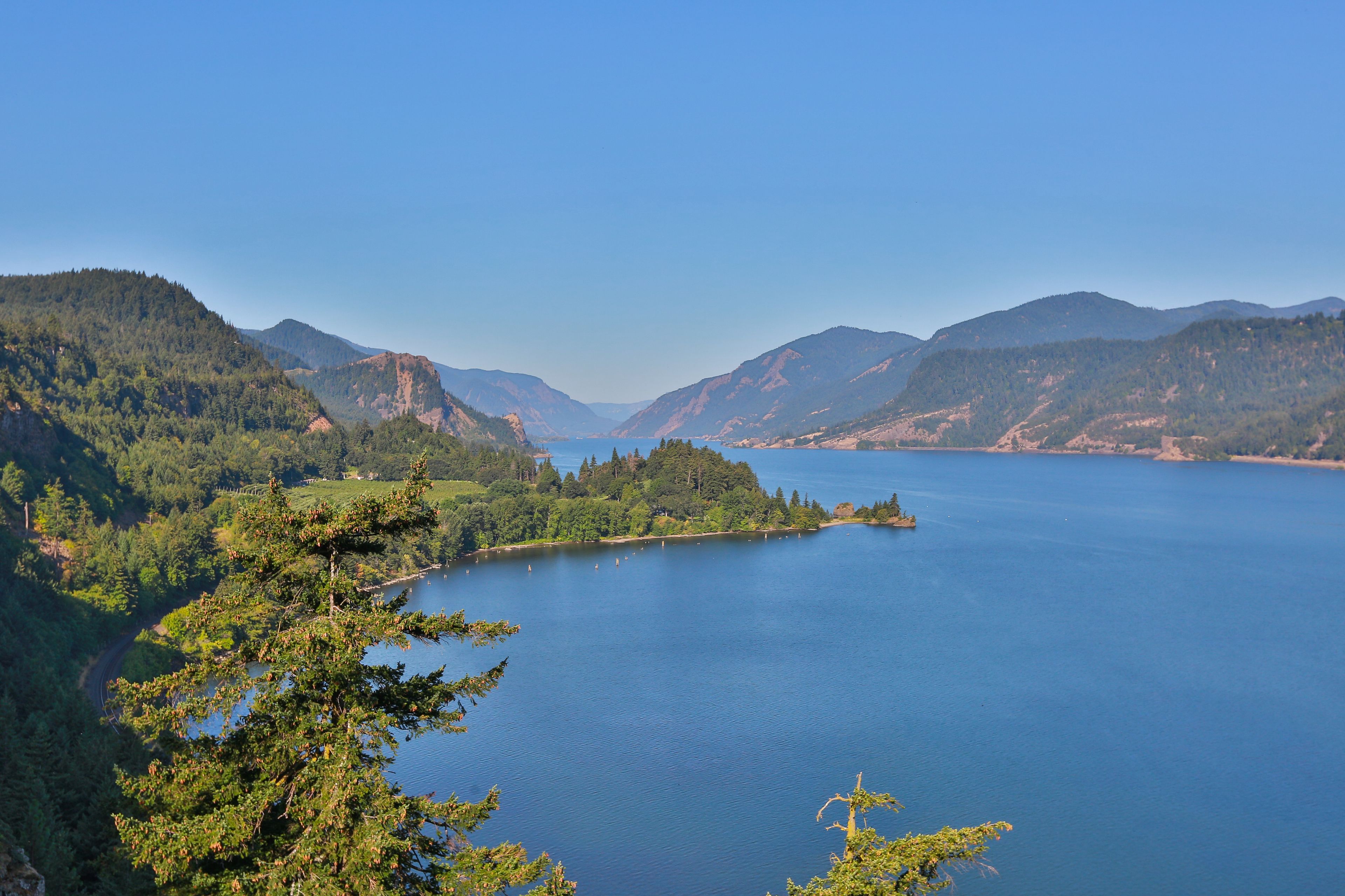 Vista panorâmica de um lago rodeado por montanhas e florestas densas.