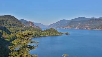 Vista panorâmica de um lago rodeado por montanhas e florestas densas.