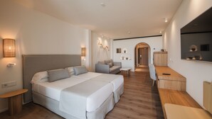 Quarto de hotel moderno com uma cama grande, uma escrivaninha e um sofá.