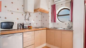 Um frigorífico/congelador grande, um micro-ondas, uma placa de cozinha