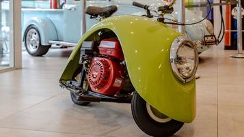 Uma motocicleta antiga com motor vermelho, banco preto e farol cromado.