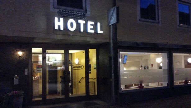 Entrada de hotel com uma placa que diz 'HOTEL'.