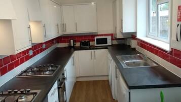 Apartamento, 4 quartos | Cozinha privada | Geladeira grande, micro-ondas, fogão, cooktop