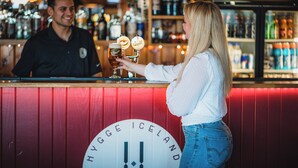 Um bar com balcão vermelho e uma placa com a inscrição 'HYGGEL ICELAND'.