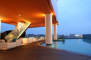 Uma área à beira da piscina com espreguiçadeiras e um toboágua.