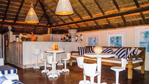 Um interior acolhedor com piso de madeira, móveis brancos e luminárias pendentes.
