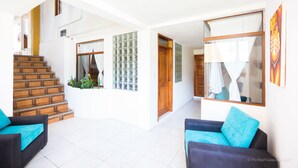 Uma sala de estar ampla com escada, porta de vidro e uma janela grande.