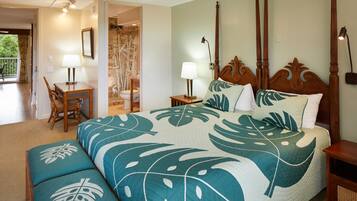 Quarto com uma cama grande, cabeceira de madeira, duas mesas de cabeceira com luminárias, uma cadeira e uma pequena mesa.