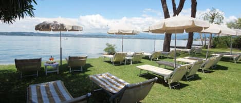 Uma praia privada, espreguiçadeiras, guarda-sóis de praia