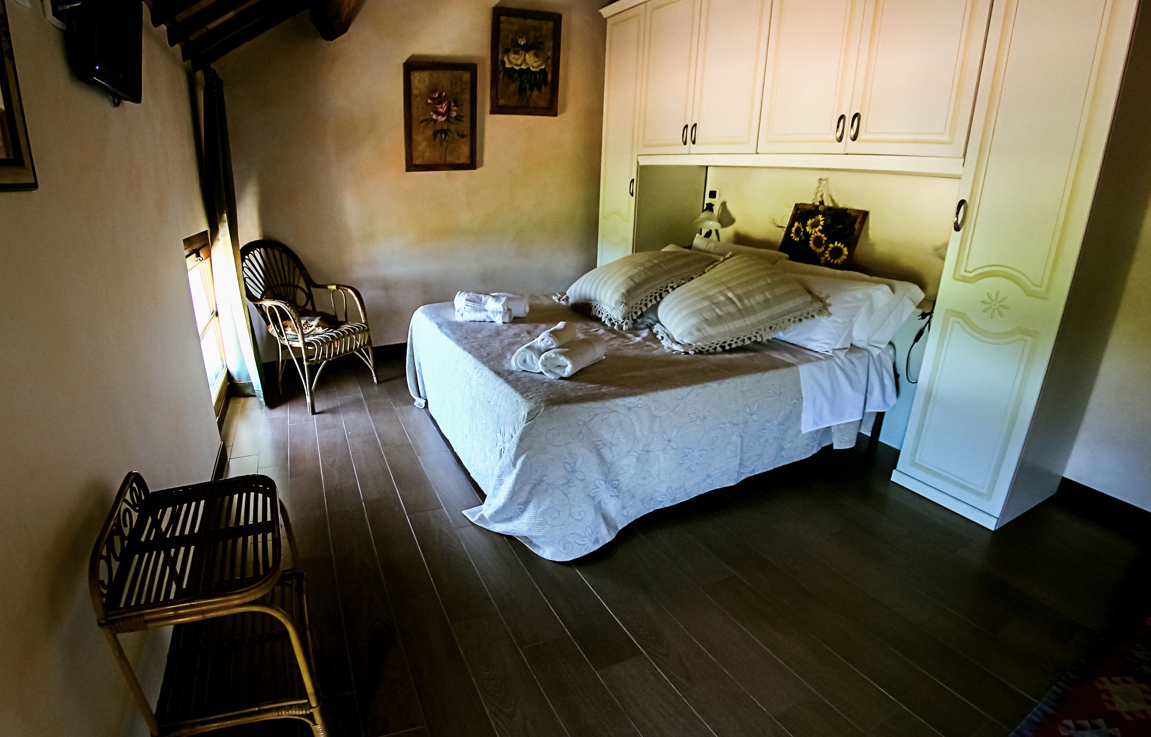 Quarto com uma cama, uma cadeira e um guarda-roupa.
