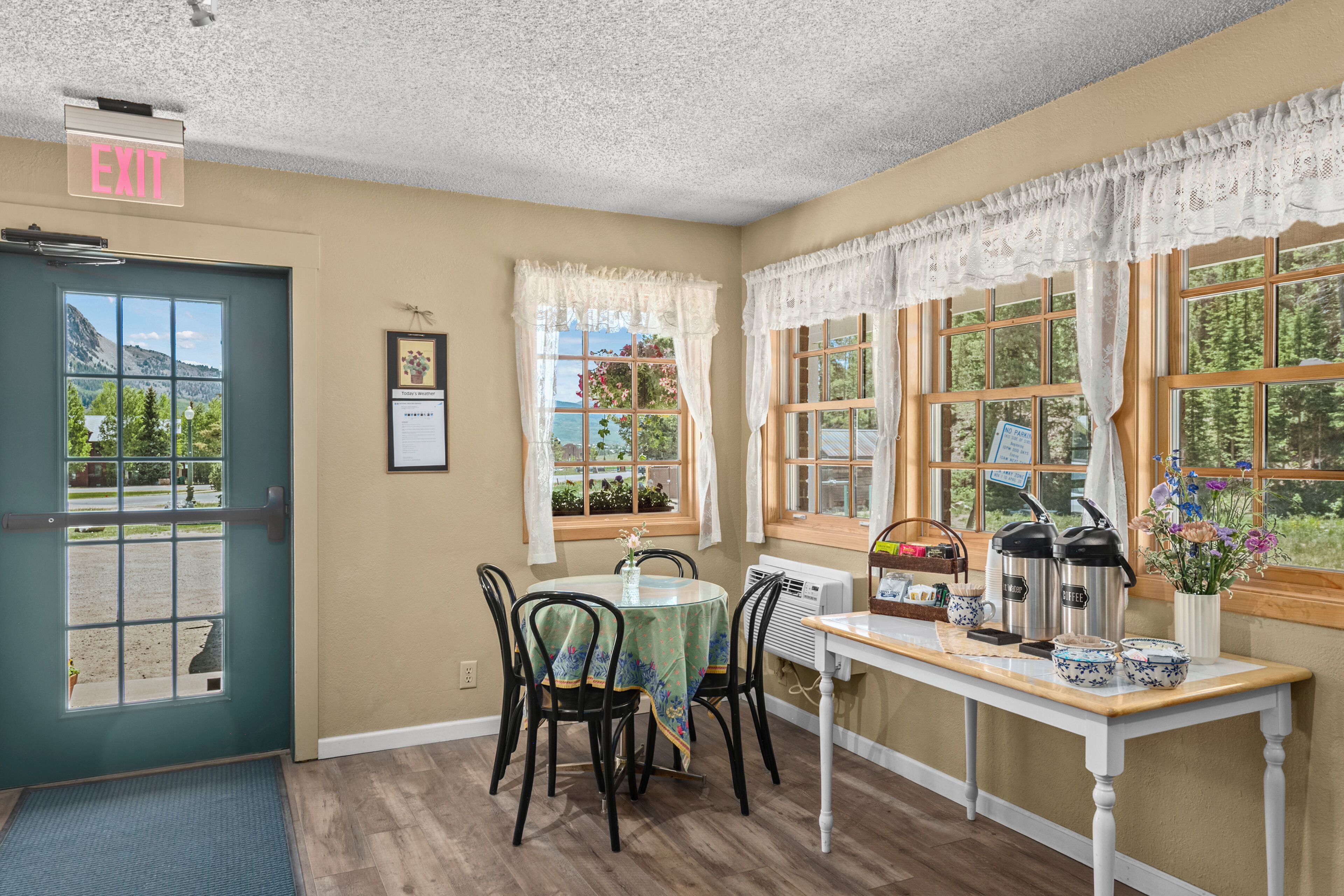 Quarto com uma mesa de jantar, cadeiras, espaço para café e vista para o exterior.