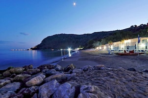 Praia particular, espreguiçadeiras, guarda-sóis