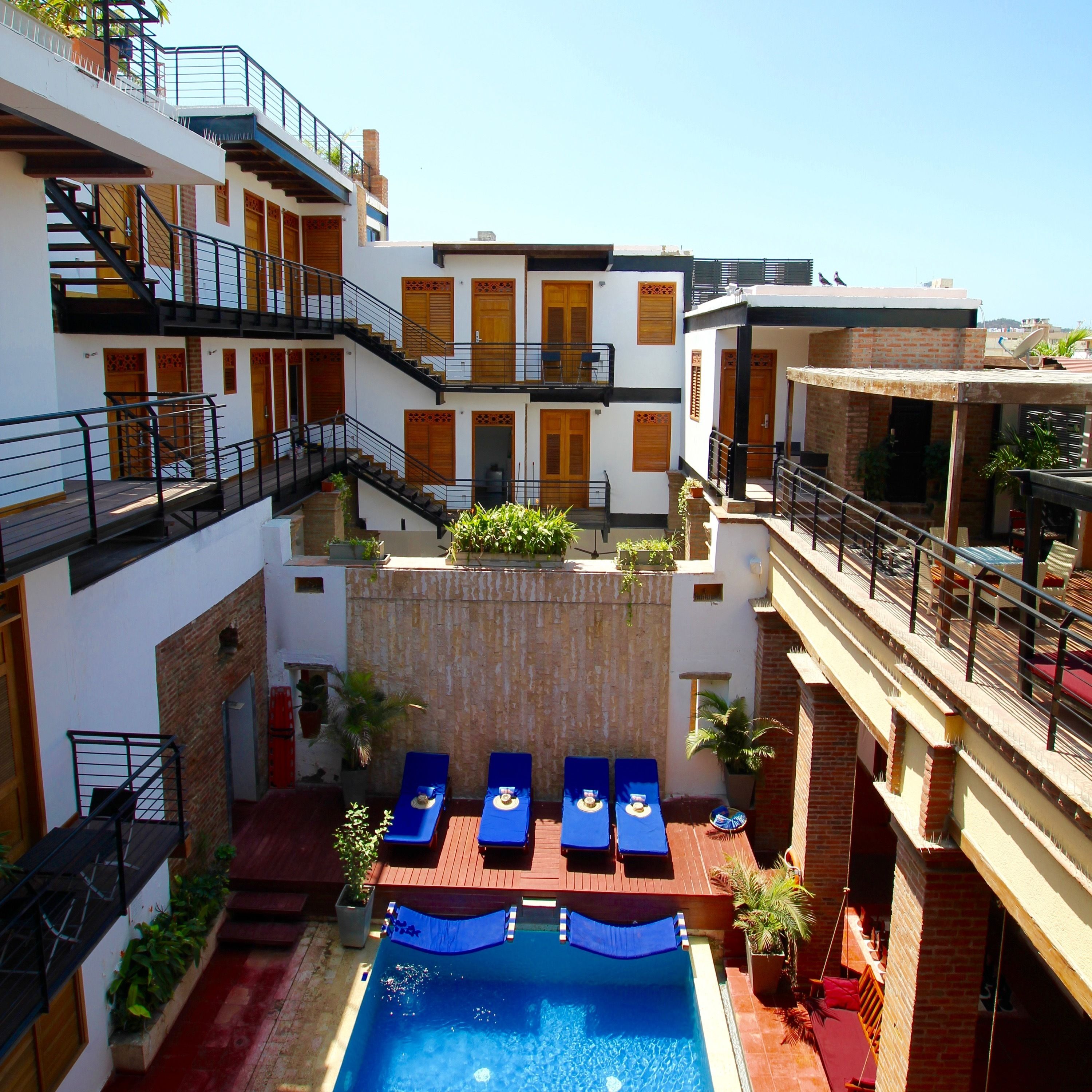 Um edifício de vários andares com piscina, varandas e áreas de estar ao ar livre.