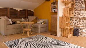 Uma sala de estar acolhedora com um sofá, uma mesinha e um tapete estampado.