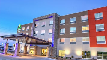 Um hotel Holiday Inn Express com fachada moderna, várias janelas e área de entrada coberta.