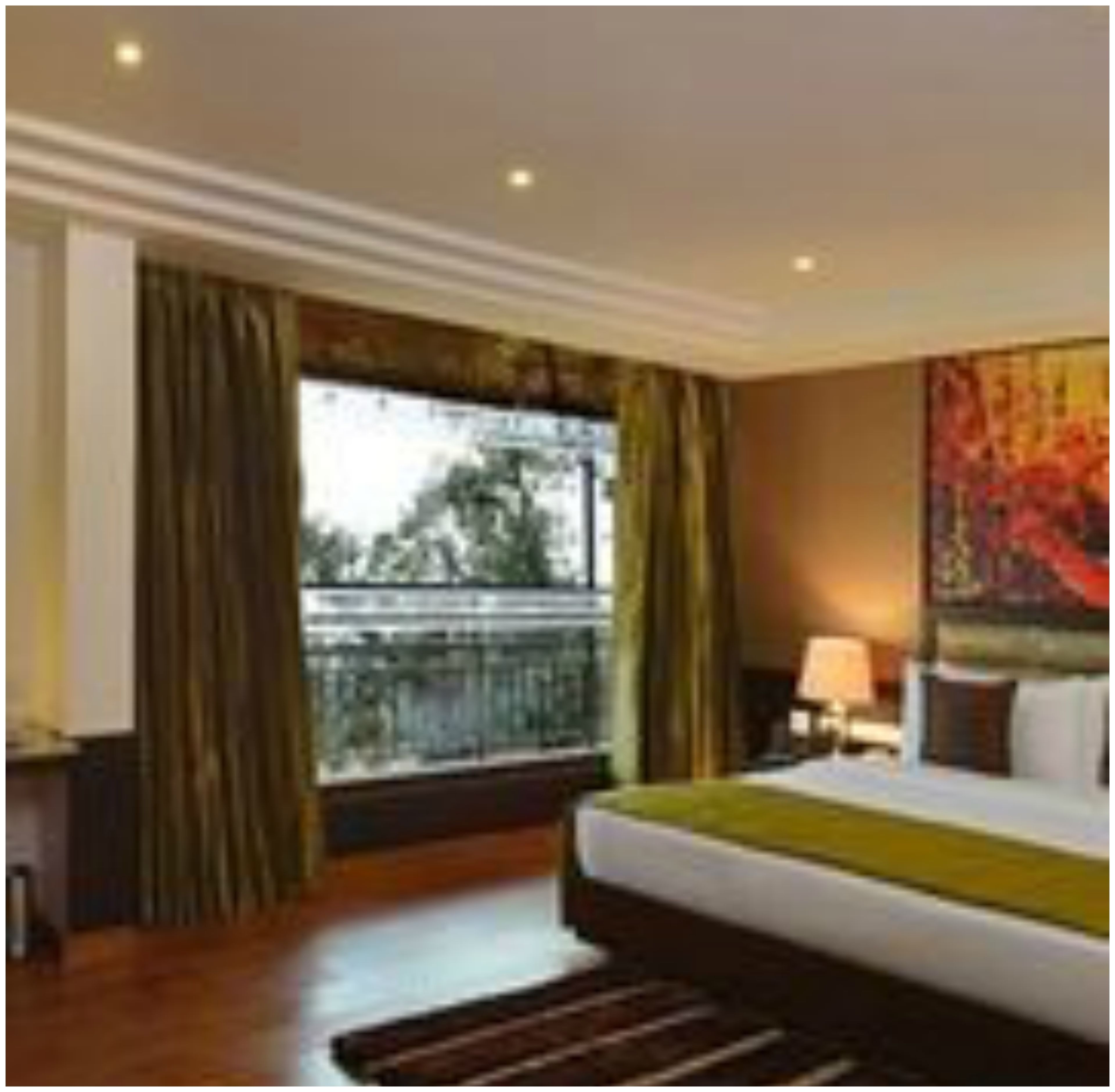 Quarto de hotel com uma cama grande, janela com cortinas, mesa de cabeceira e um quadro na parede.