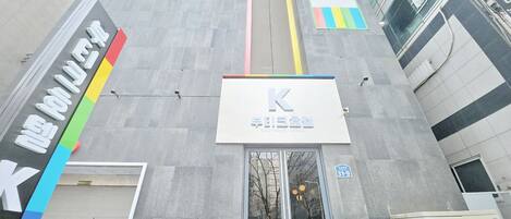 Fachada de prédio com a placa 'Boutique Hotel K' e um grande logotipo 'K'.