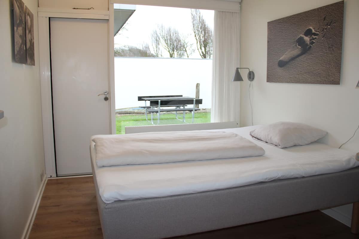 Quarto com cama, janela e vista para o exterior.