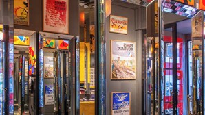 Um hall de entrada com paredes espelhadas, obras de arte coloridas e piso ladrilhado.