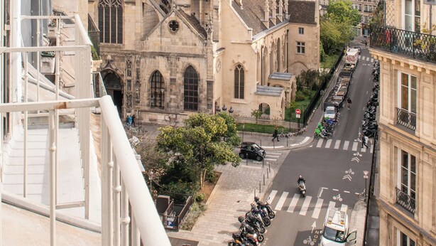 Vista da rua com uma igreja imponente e edifícios vizinhos.