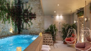 Uma área de spa com hidromassagem, assentos e plantas.