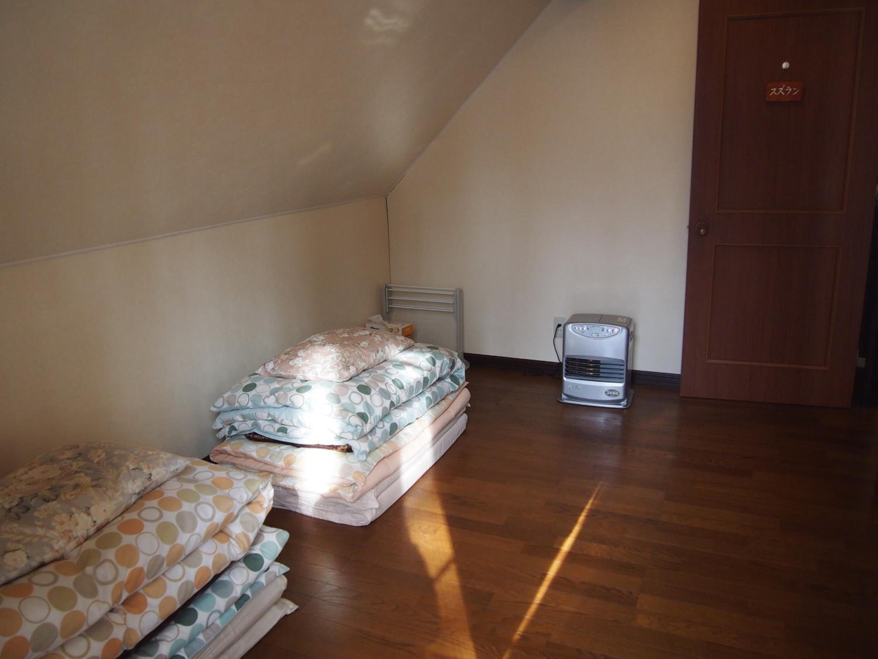 Quarto com cama, almofadas, aquecedor e porta.