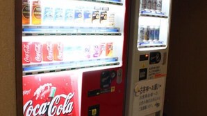 Máquina de vendas com diversas opções de bebidas, incluindo Coca-Cola.
