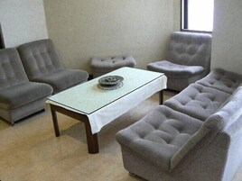 Uma sala de estar com sofá, mesa de centro e janela.